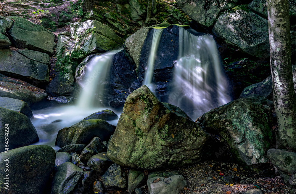 Water falling over rocks under trees with long exposure Stock Photo ...