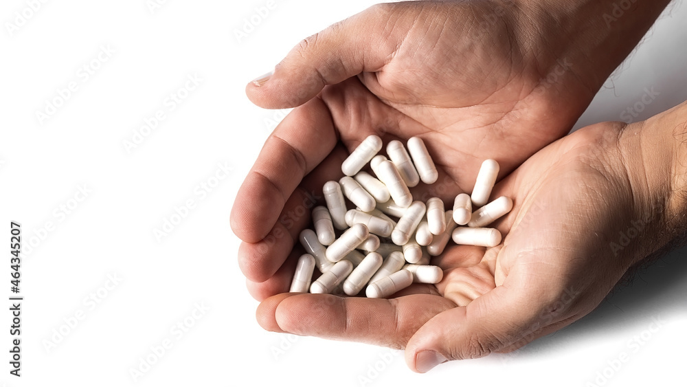 Male hands holding pills. Capsules are white. Medicines. Isolate on a ...