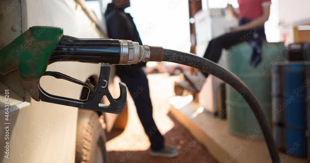 Diverse man and woman filling up truck using fuel pump at petrol ...