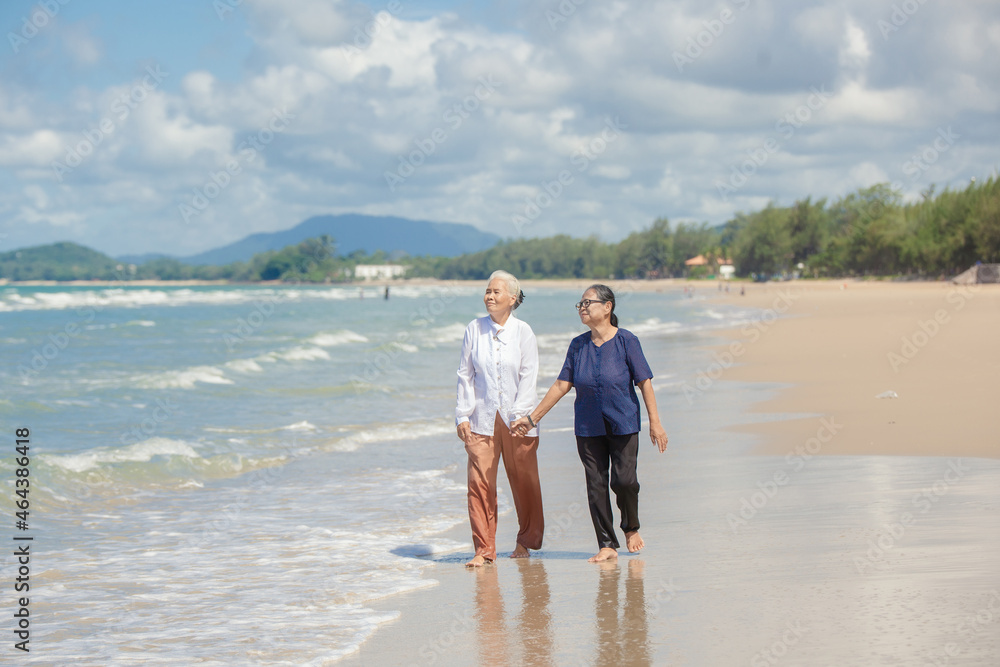 Foto de woman Asian senior elder walking together on the beach. Happy ...