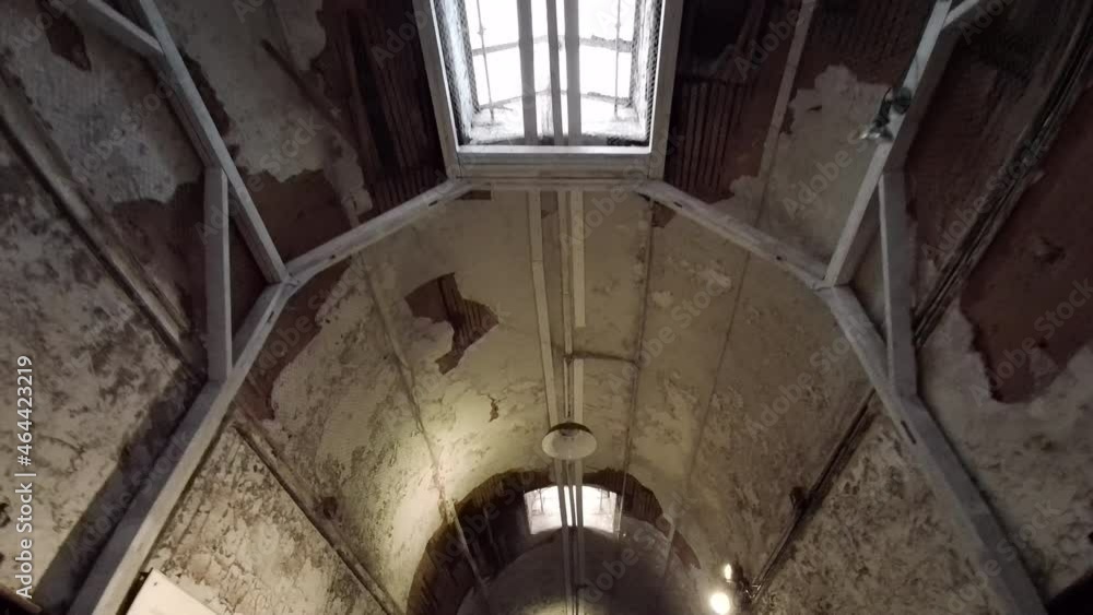 Moving view of deteriorating ceiling and skylights in prison corridor ...