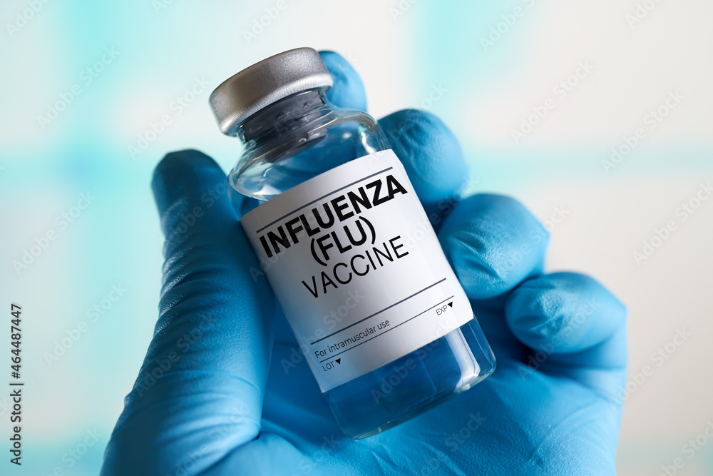 Influenza Flu Vaccine vial. Doctor with Influenza (Flu) or Grippe vaccine bottle for the annual ...