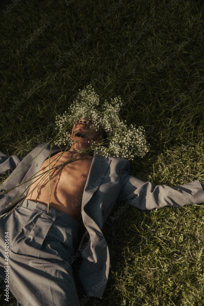 male model laying down in field Stock Photo | Adobe Stock