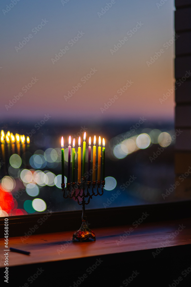 lights the menorah for Hanukkah at sunset sky. Jewish holiday ...