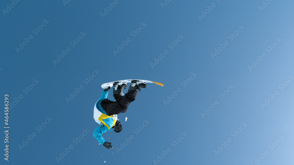 Man snowboarding performs spectacular grab flip while riding in ...