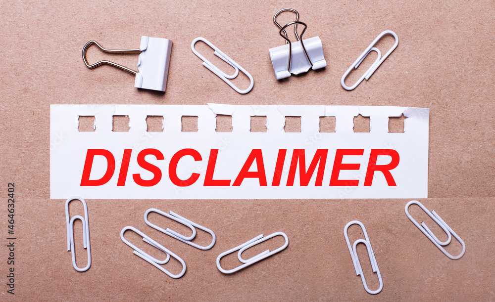 On a brown background, white paper clips and a torn strip of white ...