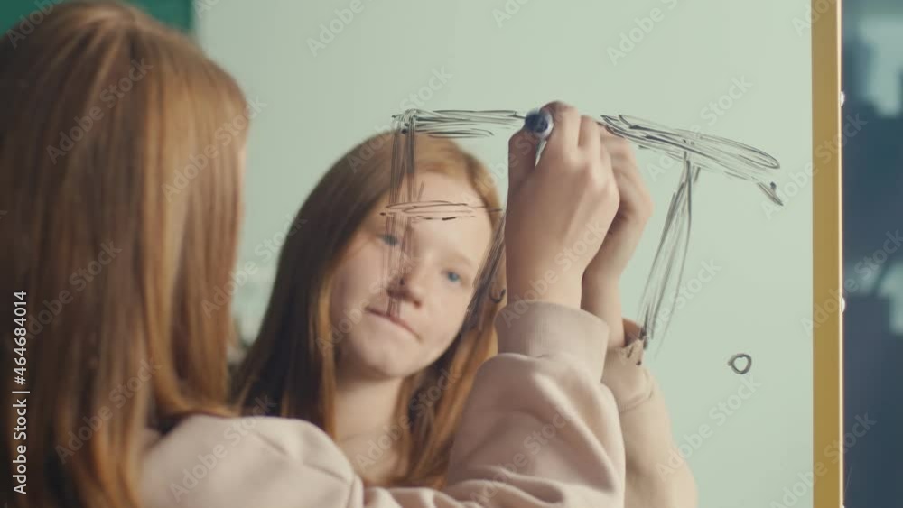 Reflection of a Red haired Teenage Girl Writing an Inscription on a ...