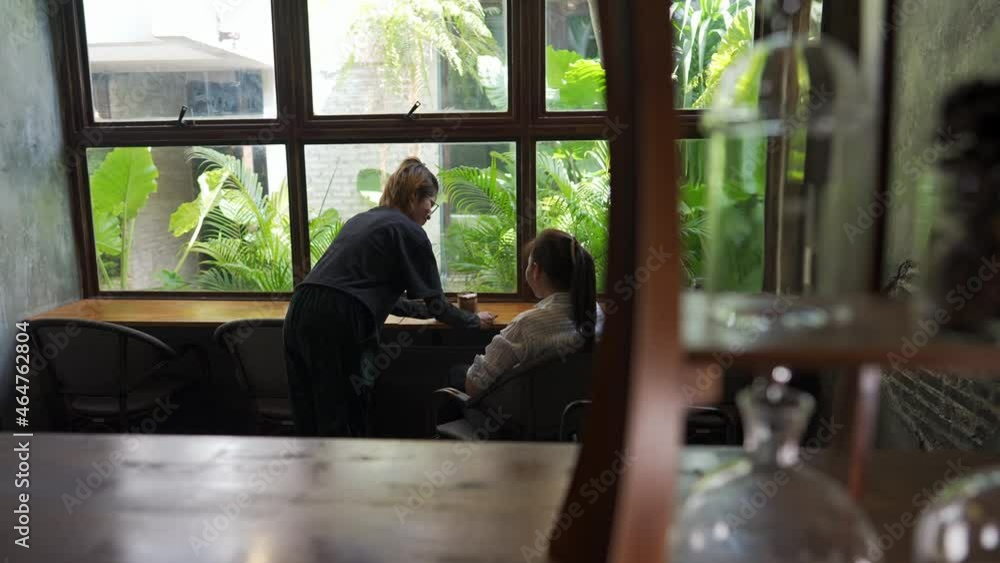 Asian woman barista serving iced chocolate with milk to customer ...