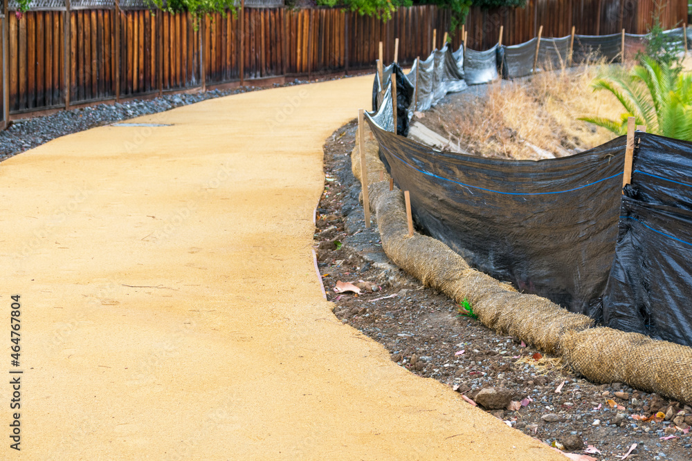 Straw wattle and plastic fence are placed along the waterway to reduce ...