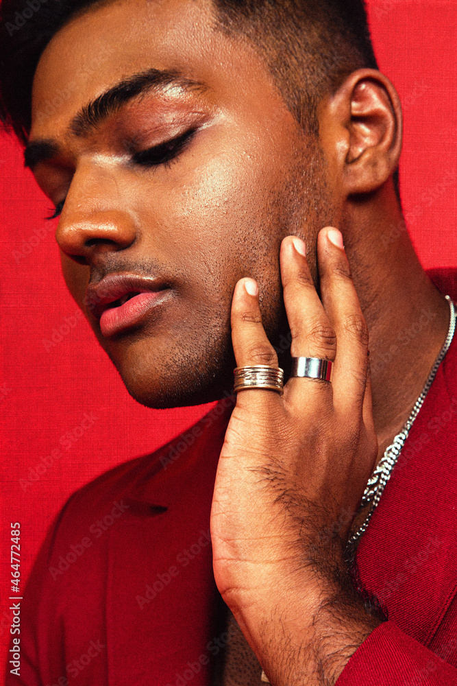 Malaysian Indian individual dressed in red clothing, against a red ...