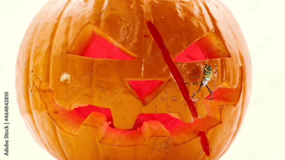 Halloween concept, a pumpkin with a scar on the red eyes on white ...