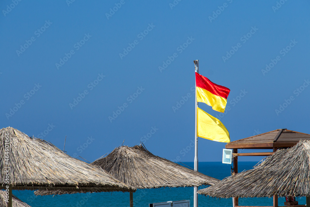 Yellow-red and yellow beach warning flags on the hotel plage ...