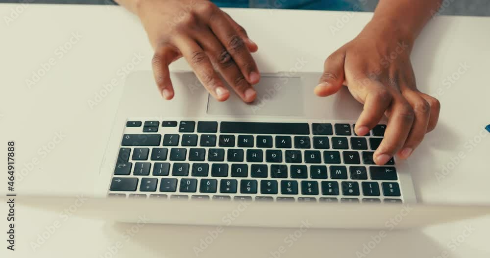 Close-up of silver latop standing on white desk, dark-skinned man ...
