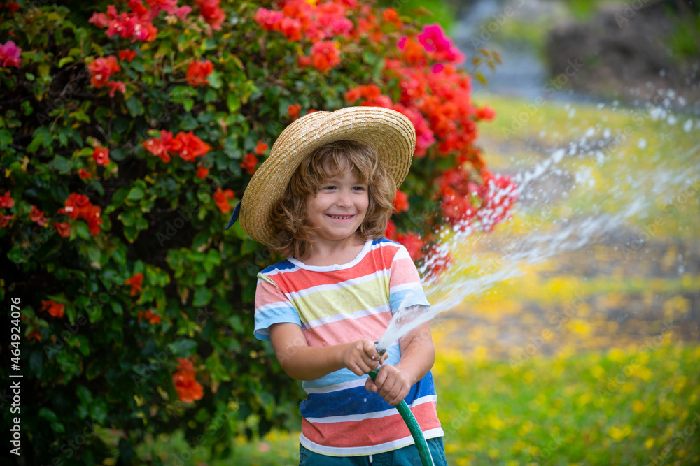 Funny little boy playing with garden hose in backyard. Child having fun ...