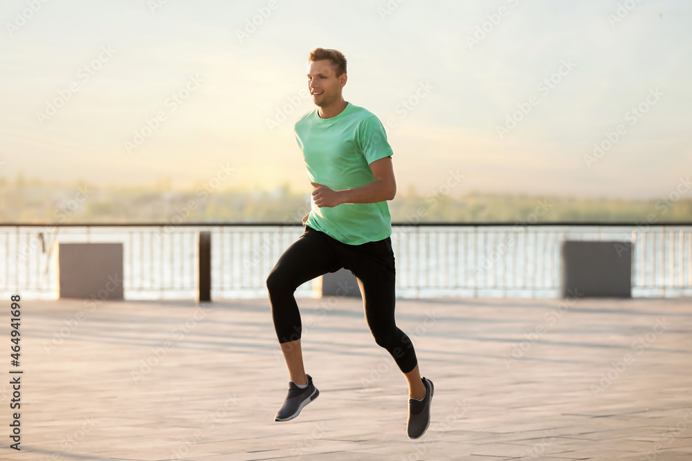 Handsome young man running near river Stock Photo | Adobe Stock