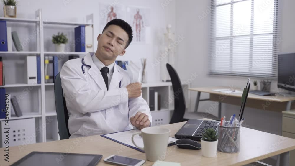slow movement exhausted asian medical doctor is taking off his surgical ...
