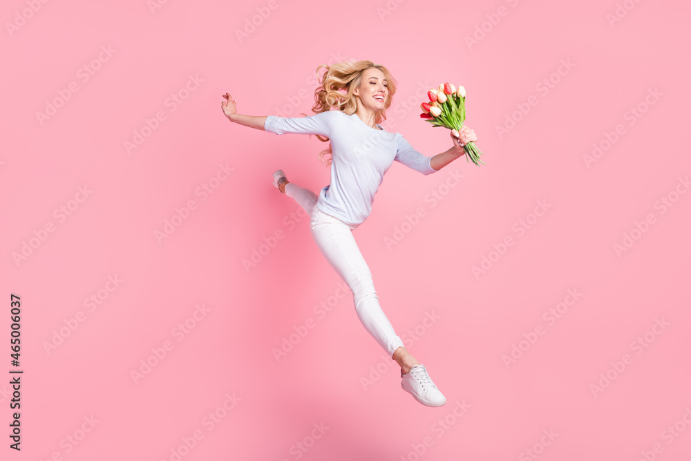 Full size photo of happy cheerful young,woman jump up look flowers ...