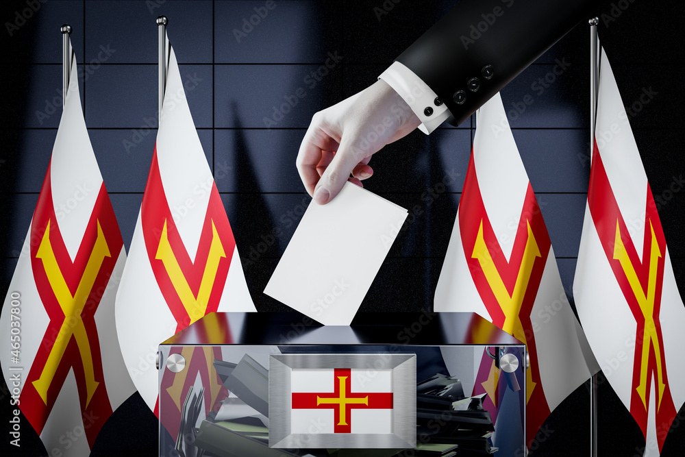 Guernsey flags, hand dropping ballot card into a box - voting, election ...