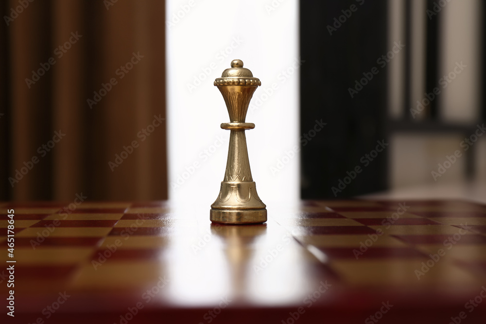 Golden Queen chess piece on board indoors Stock Photo | Adobe Stock