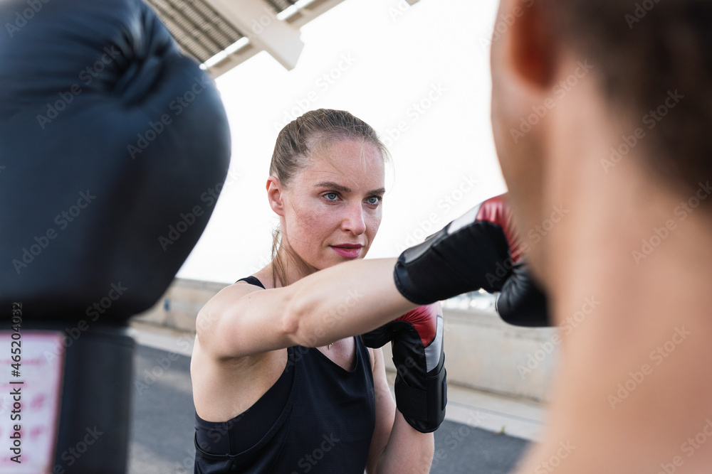 Concentrated female athlete practicing boxing with male coach Stock ...