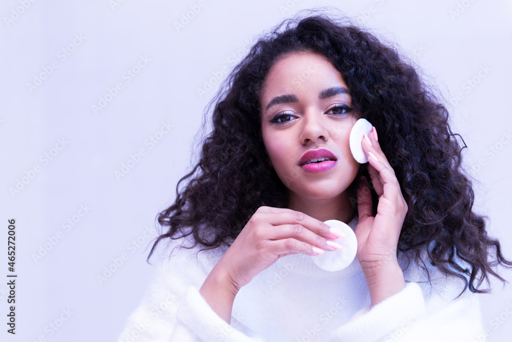 Black 20s young female do daily skincare routine cleanses skin using ...