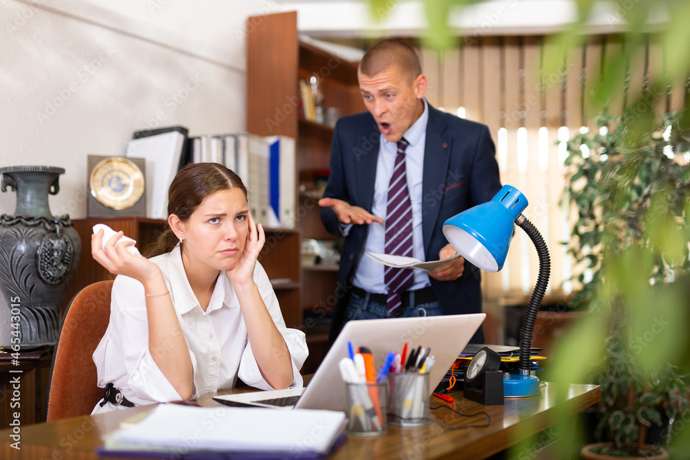 Young businessman who is in the office scolds his subordinate girl ...