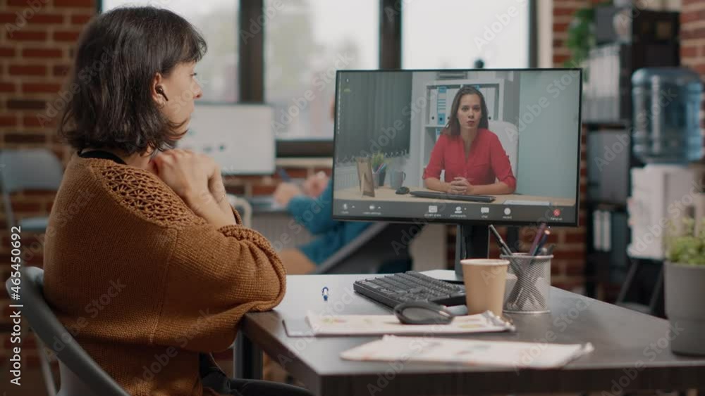 Employee waving at video call camera to talk to manager on computer ...