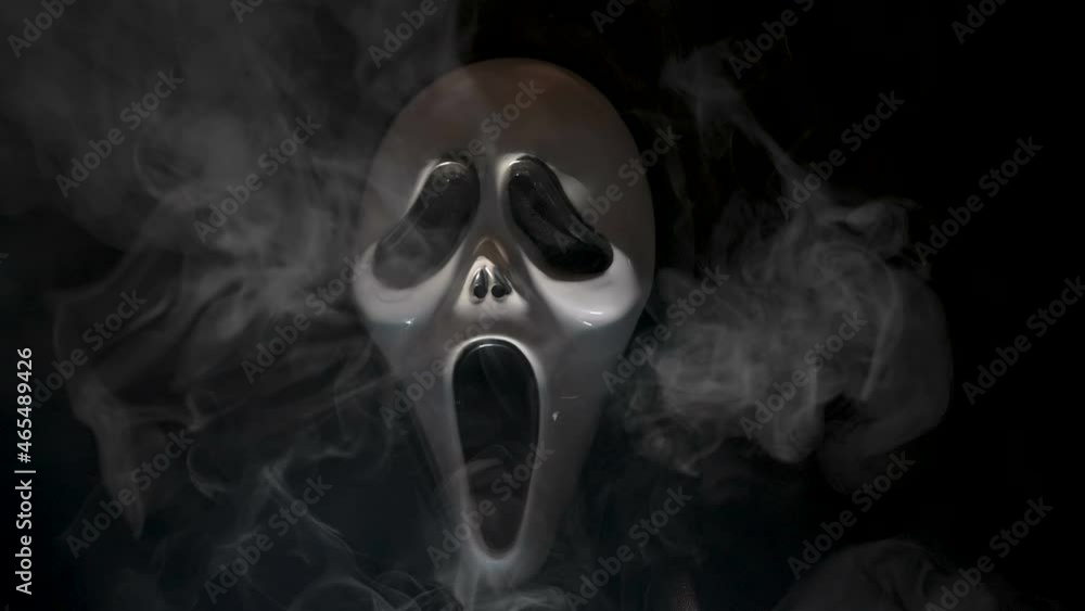 Scary ghost mask with the white smoke on the back during the halloween ...