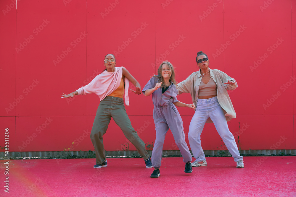 Dancing stylish girls having fun showing energetic street dance on red ...