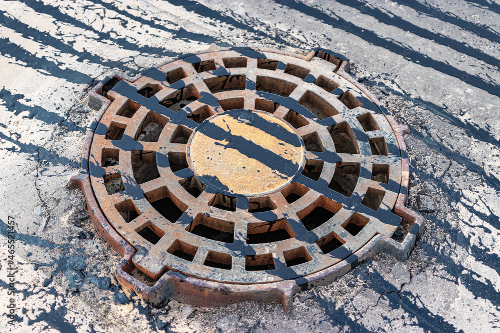A cast-iron storm sewer hatch on the road before laying the asphalt ...