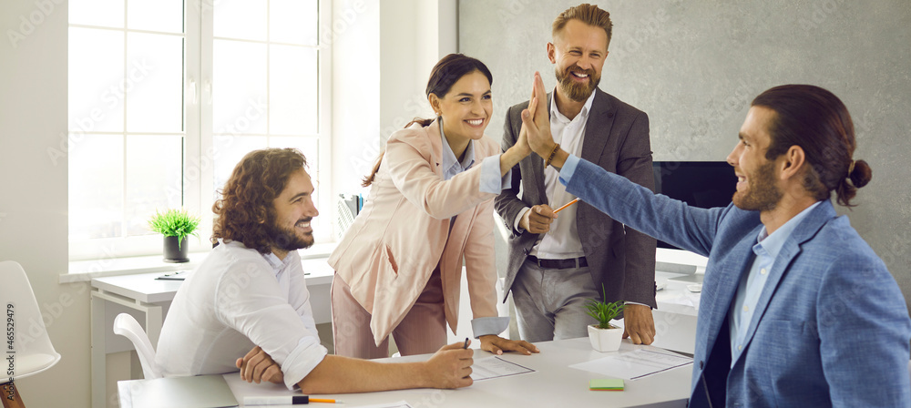 Happy smiling young business people making deal and giving each other ...