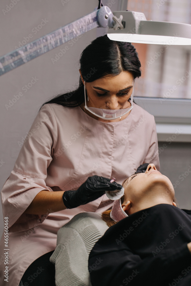 eyebrow microblading. A master in a transparent mask on his face and ...