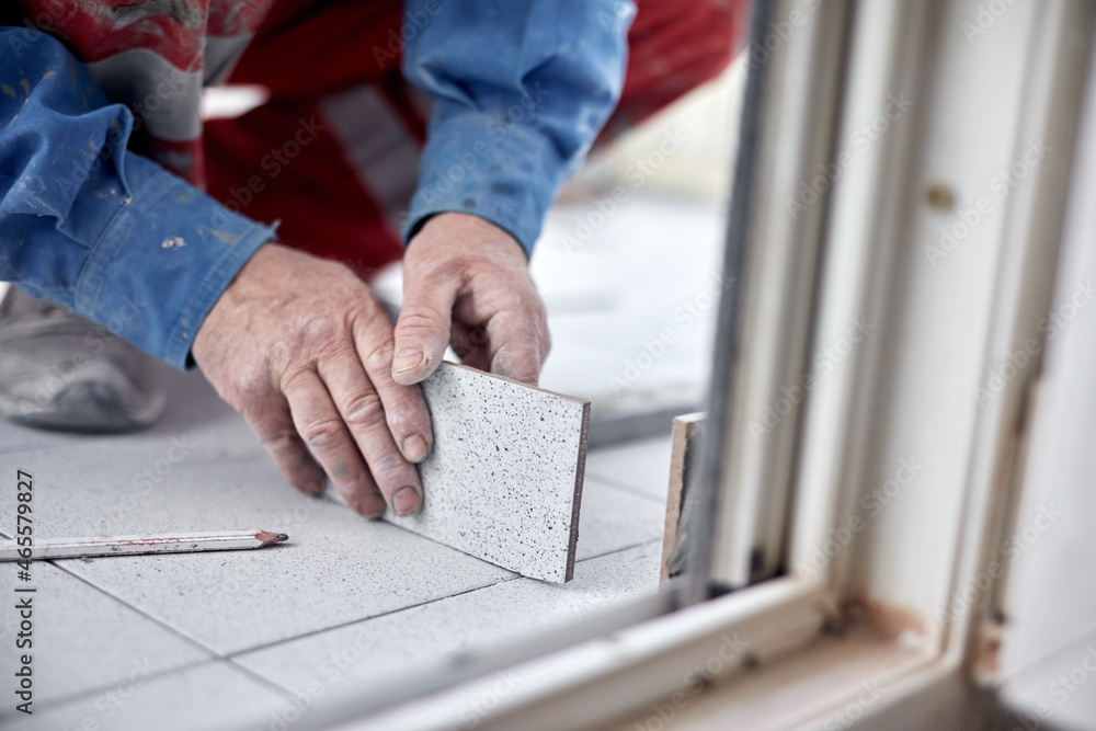 Professional ceramics tile man worker placing new tiles on the floor ...