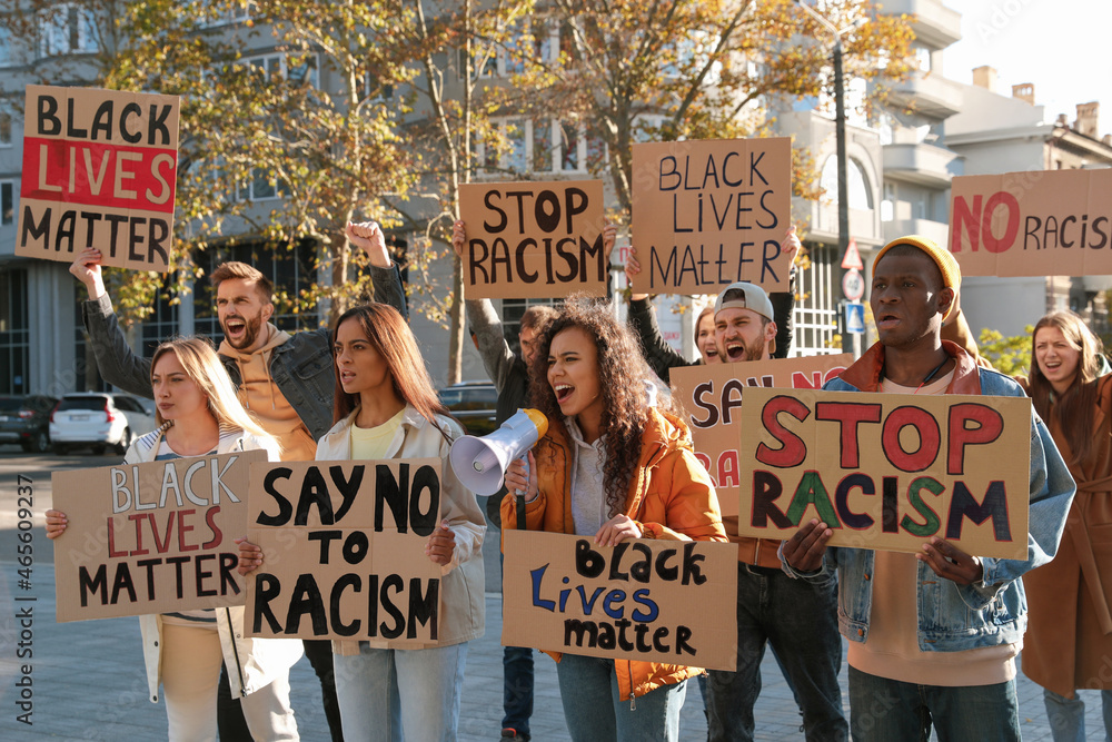 Protesters demonstrating different anti racism slogans outdoors. People ...