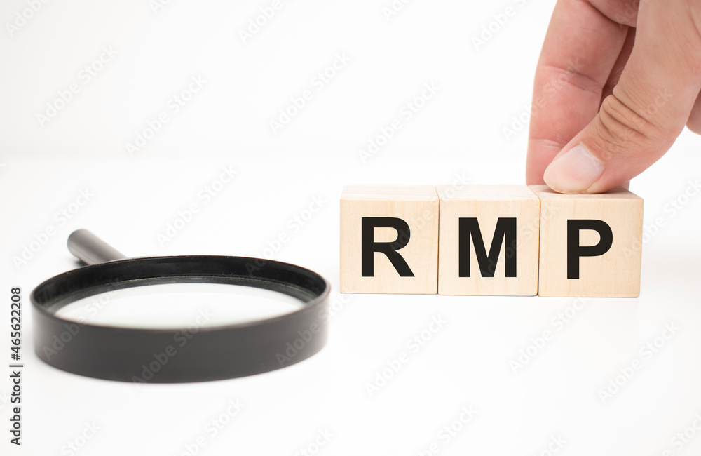 rmp text wooden cube blocks and hand holding magnifying glass on table ...