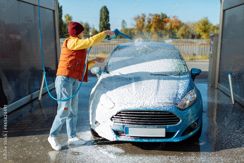 portrait young, smiling, happy, attractive woman washing automobile at ...