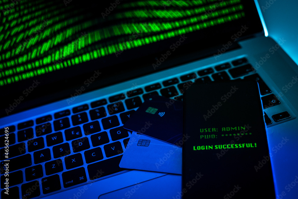 Laptop with green numbers on display. Credit cards, smartphone ...