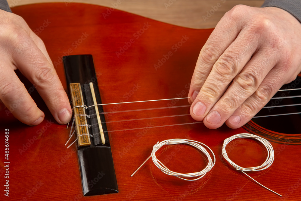 replacement and insertion of nylon strings in a classical guitar ...