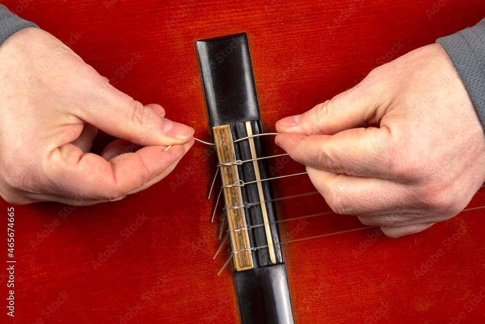 replacement and insertion of nylon strings in a classical guitar ...