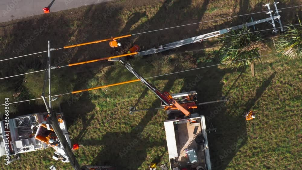 Construction site with people replacing pole for power line, renovation ...