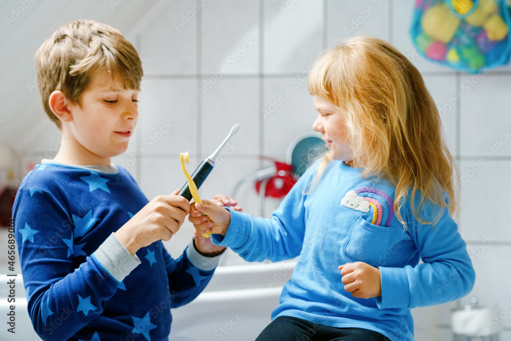 Little preschool girl and preteen school boy brushing teeth. Brother ...