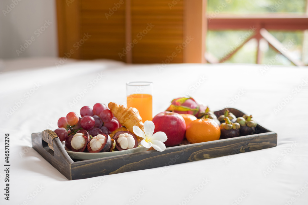 Focus on fruit. In a hotel room with fruit, place a tray on the bed to ...