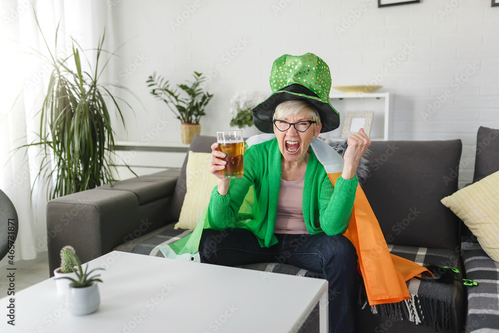 Old Irish lady watching the game on a computer, drinking beer, cheering ...