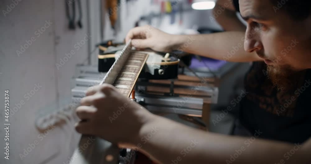 Luthier measures the fretboard angle of the electrick guitar neck on ...