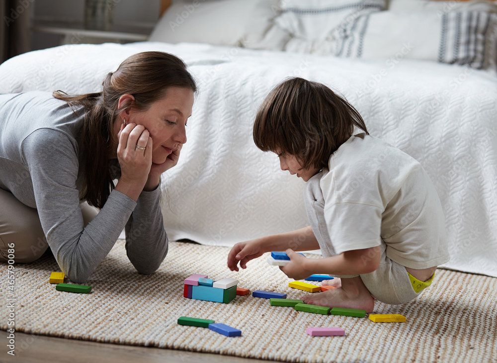 Confident family mom and son building multicolored bricks playing ...
