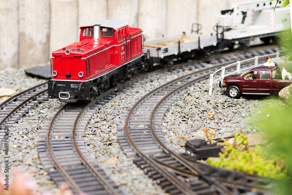 Set of red electric model railway locomotive and layout with a station ...