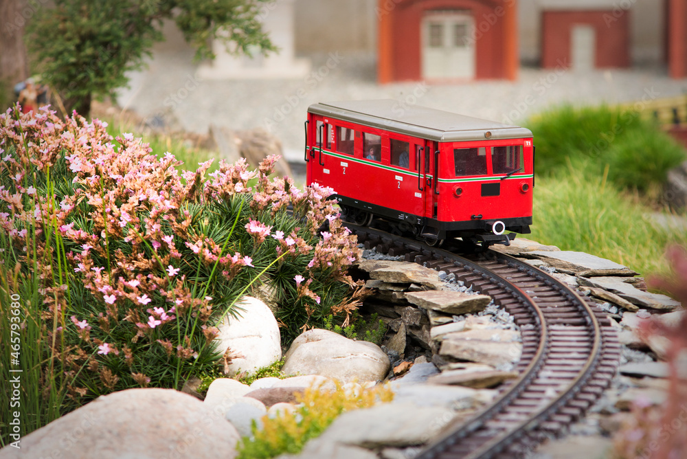 Set of red electric model railway locomotive and layout with a station ...