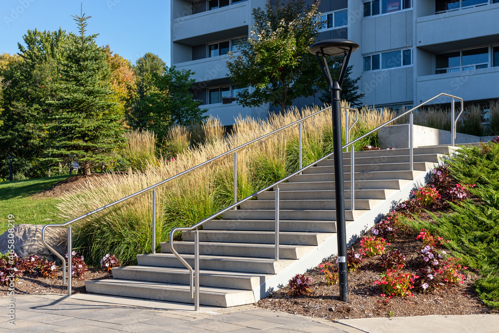 Apartment building front yard with stairs leading to the entrance and ...