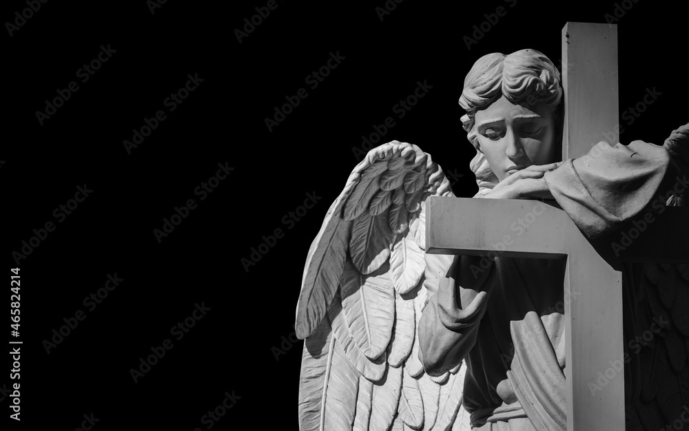 Beautiful sad angel with cross. Fragment of an ancient statue with a ...