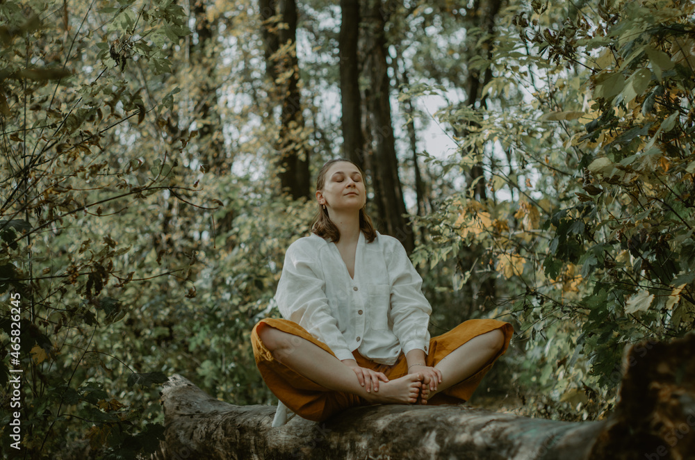 Person sitting on a fallen tree in the middle of the forest, barefoot ...